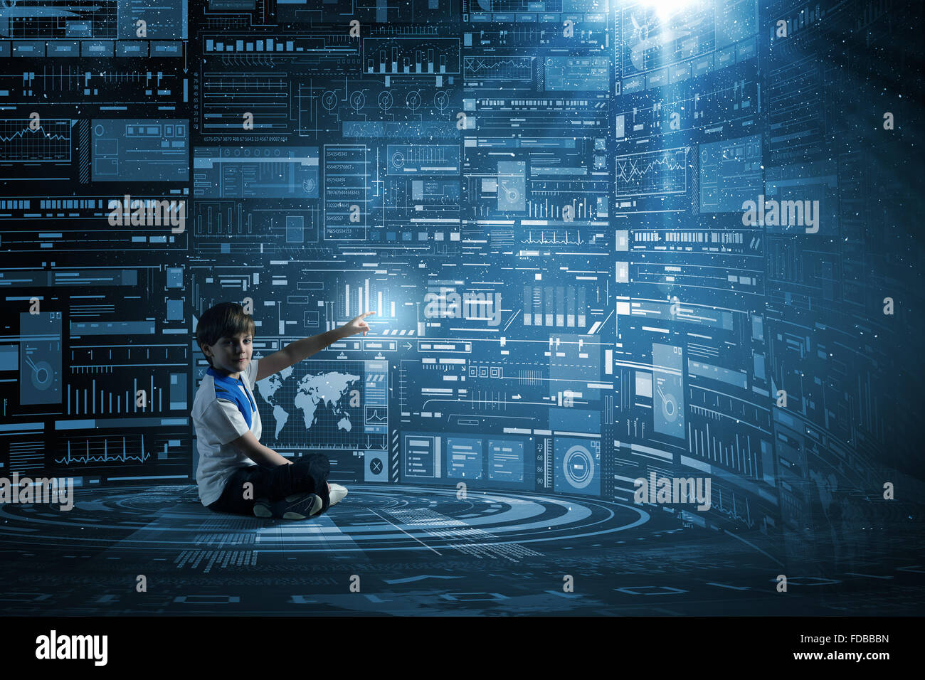 Cute school boy sitting on floor and touching digital screen with ...