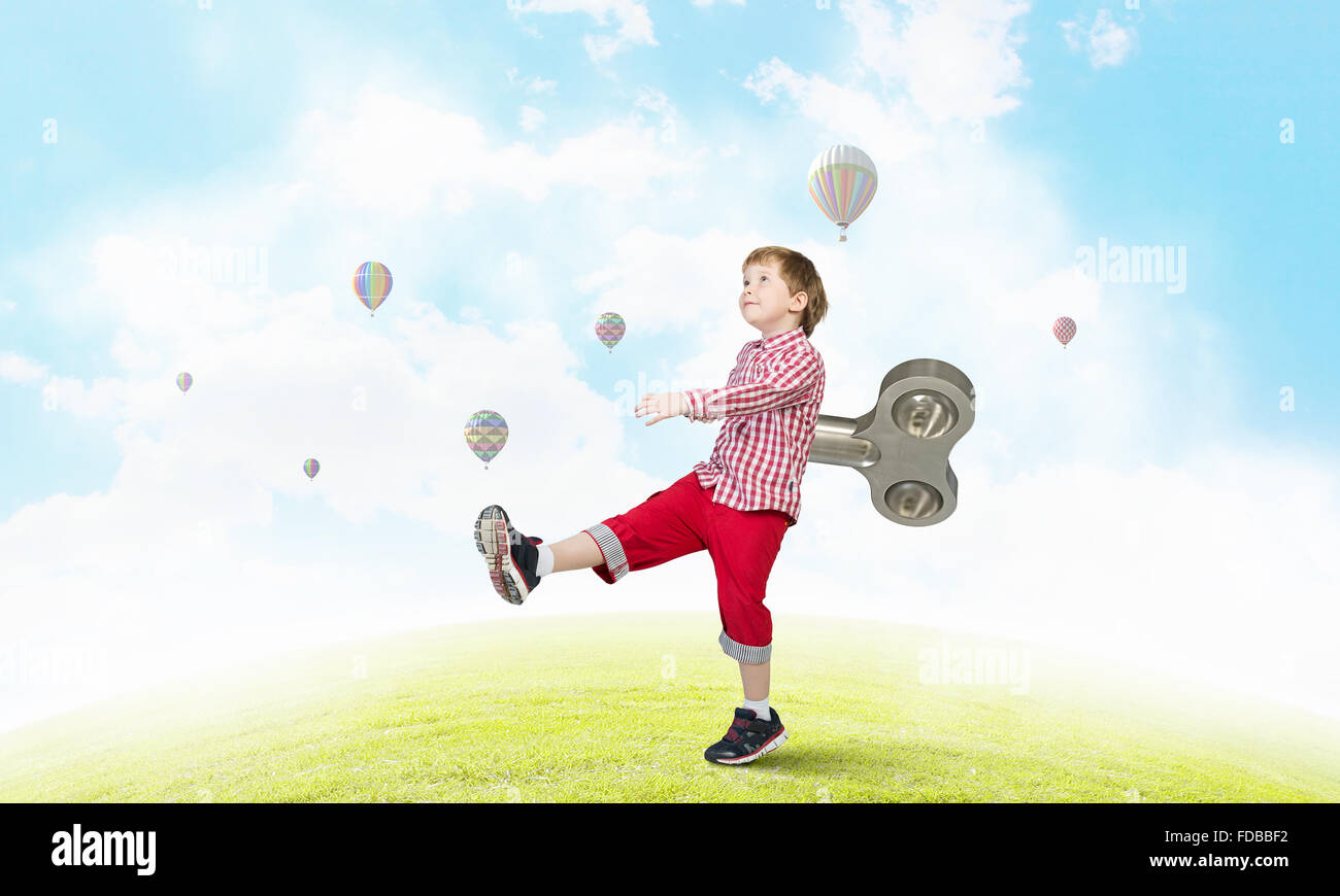 Little cute active boy with key on back Stock Photo - Alamy