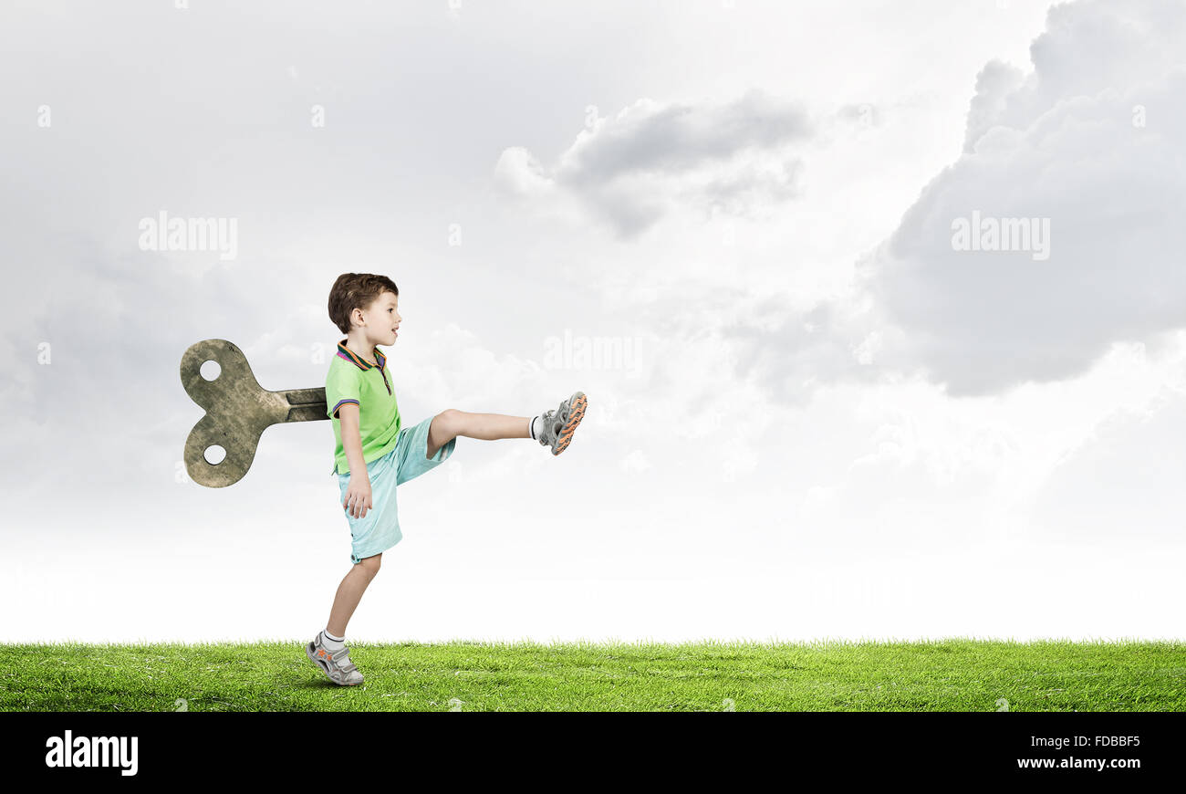 Little cute active boy with key on back Stock Photo - Alamy