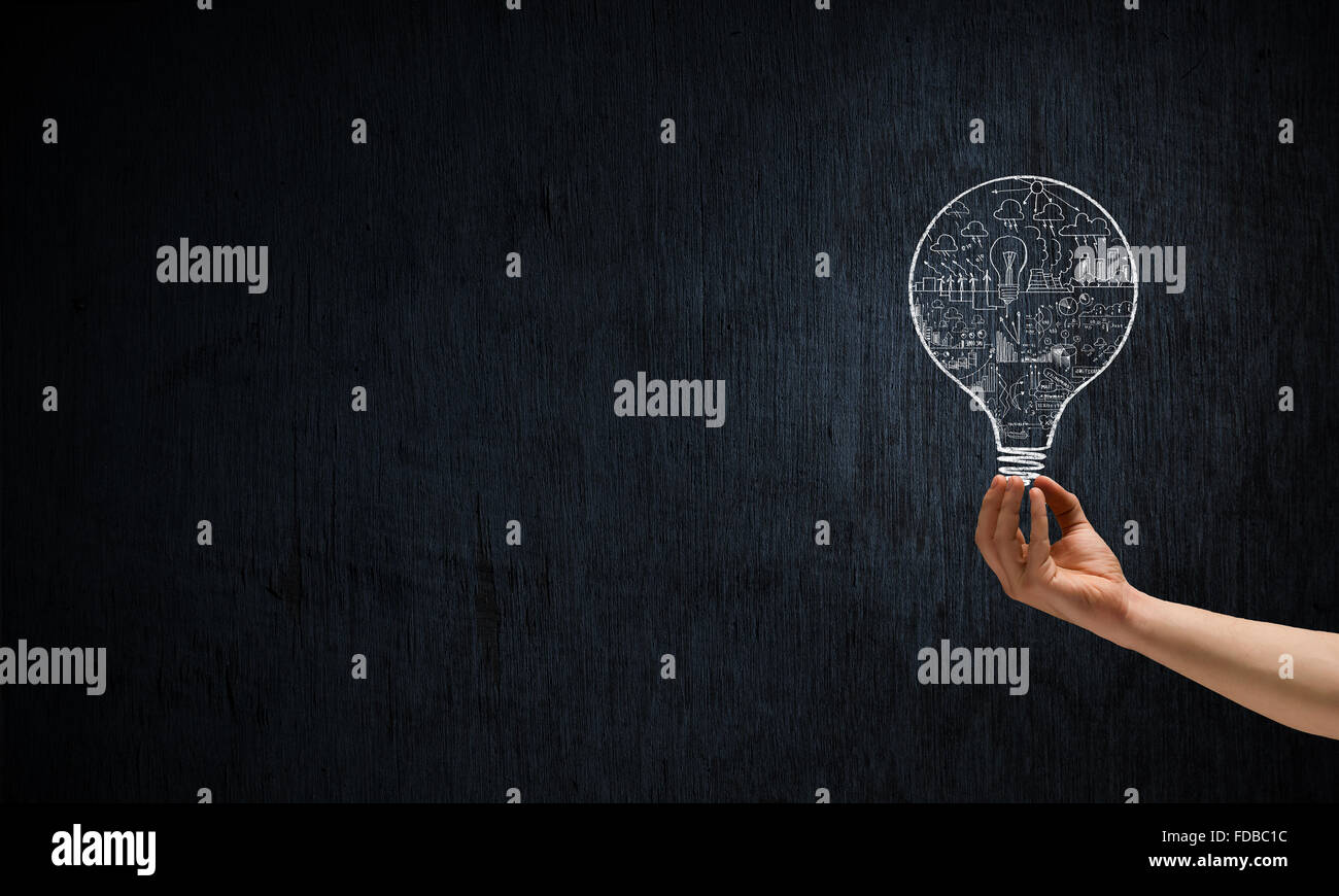 Male hand on dark background showing drawn light bulb Stock Photo - Alamy