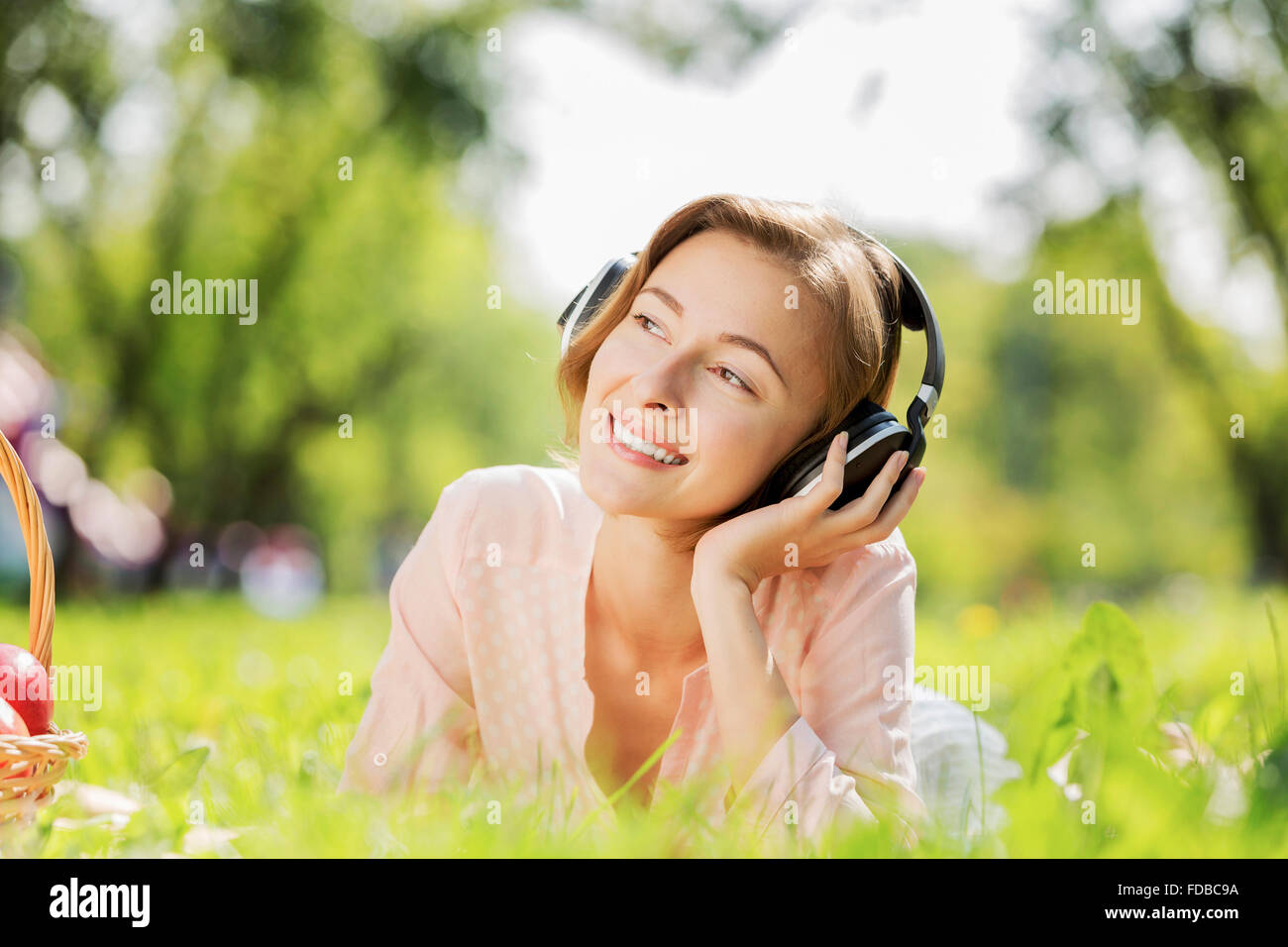 Young pretty lady in park listening to music Stock Photo - Alamy