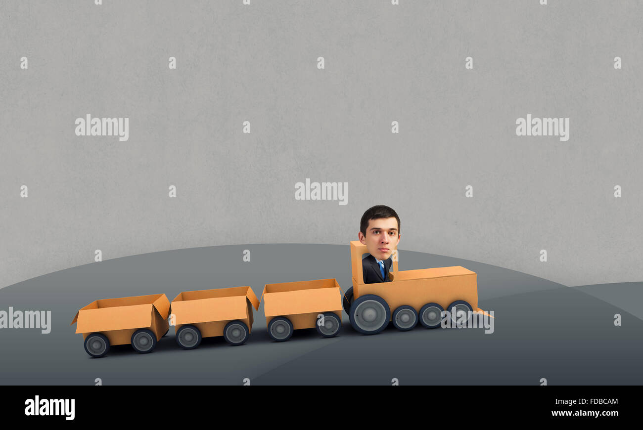 Funny image of businessman riding in carton train Stock Photo - Alamy