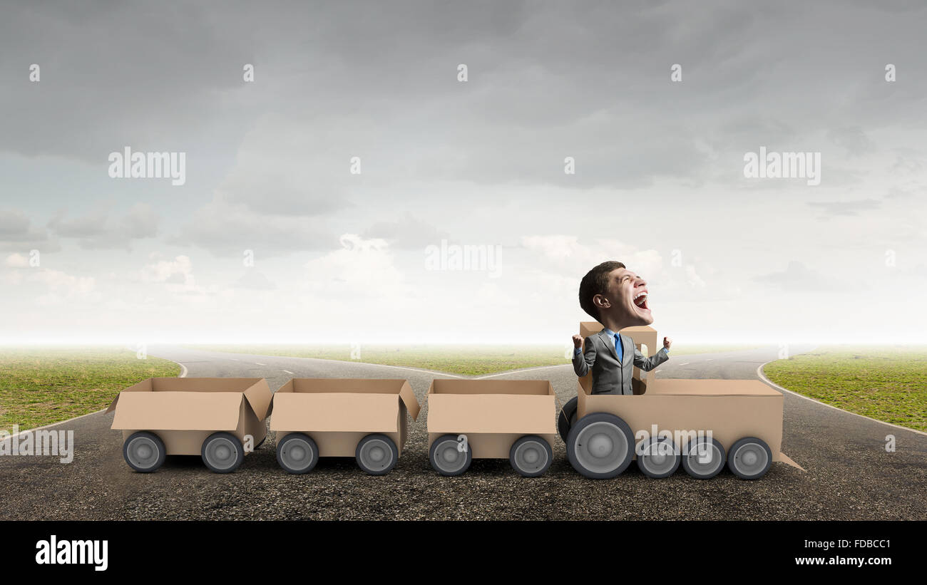 Funny image of businessman riding in carton train Stock Photo - Alamy