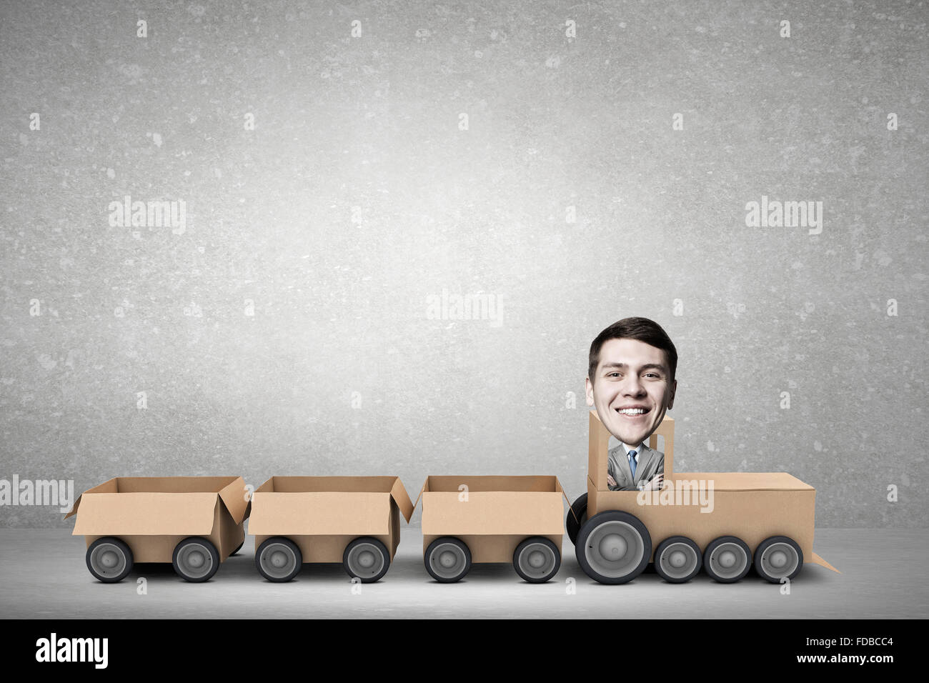 Funny image of businessman riding in carton train Stock Photo - Alamy