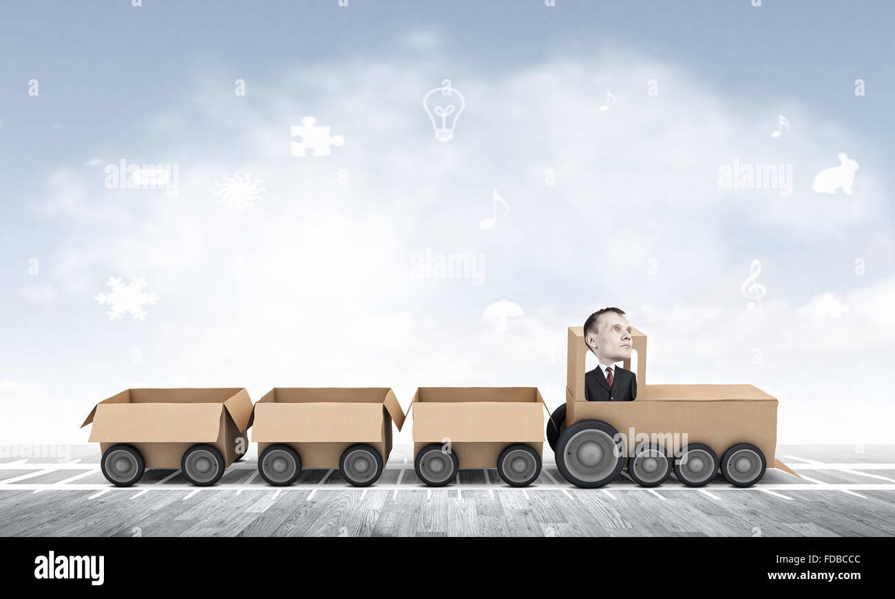 Funny image of businessman riding in carton train Stock Photo - Alamy