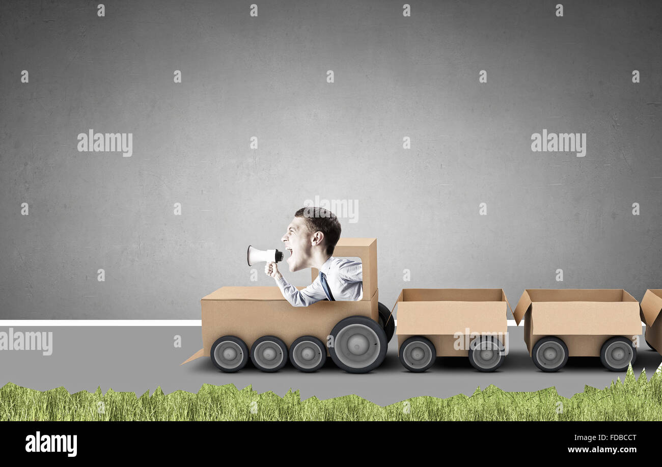 Funny image of businessman riding in carton train Stock Photo - Alamy