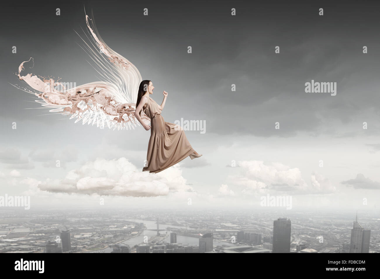 Attractive woman running with angel wings behind back Stock Photo - Alamy