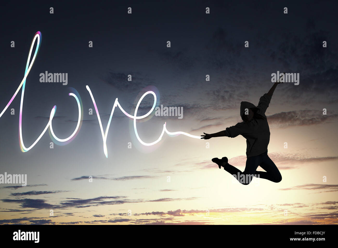 Young girl jumping high in sky and drawing love word Stock Photo - Alamy