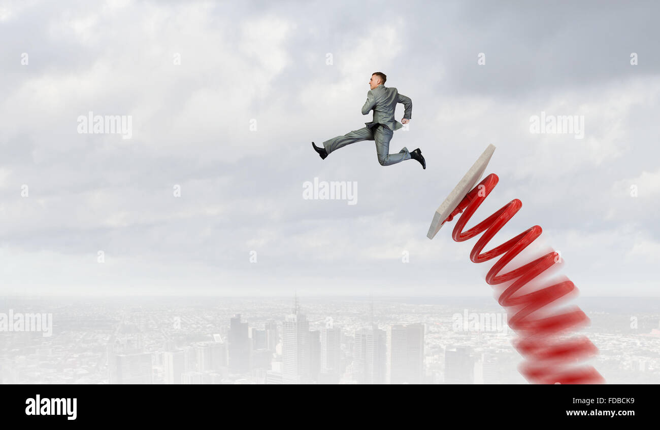 Businessman jumping on springboard as progress concept Stock Photo - Alamy