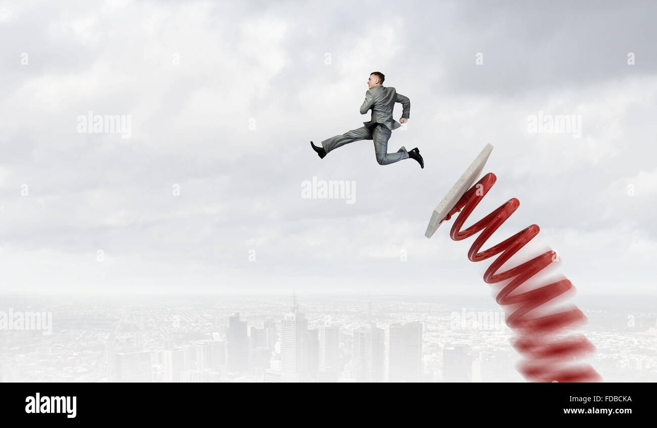 Businessman jumping on springboard as progress concept Stock Photo - Alamy