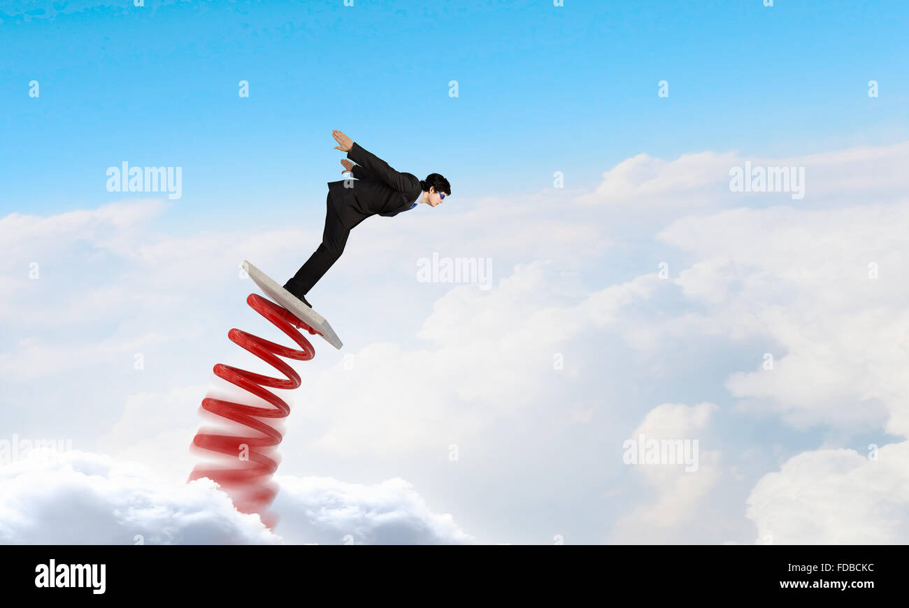 Businessman jumping on springboard as progress concept Stock Photo - Alamy