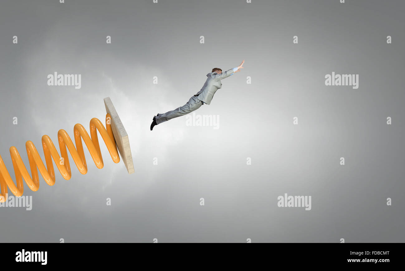 Businessman jumping on springboard as progress concept Stock Photo - Alamy