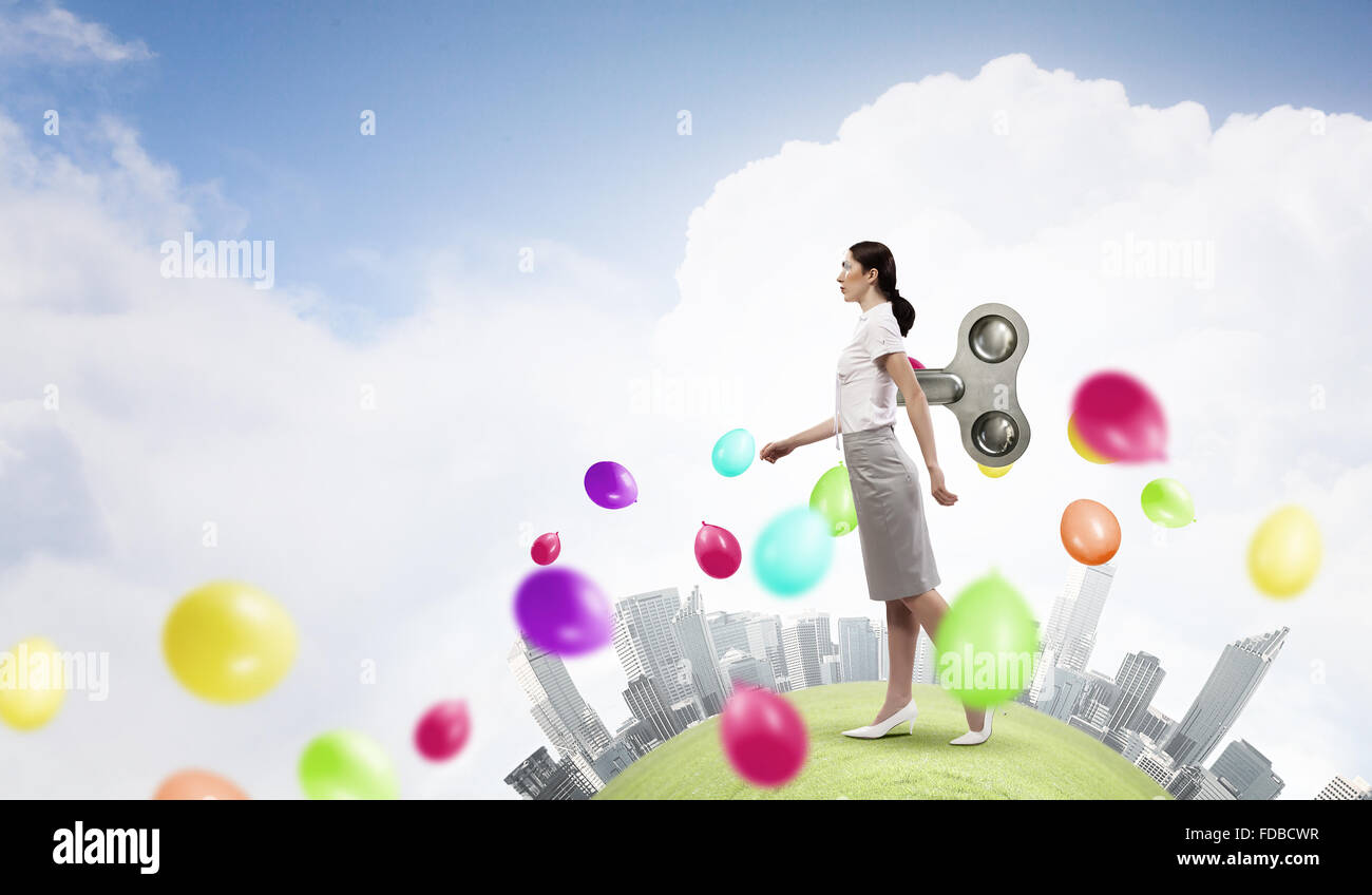 Young businesswoman walking with wind up key in his back Stock Photo ...