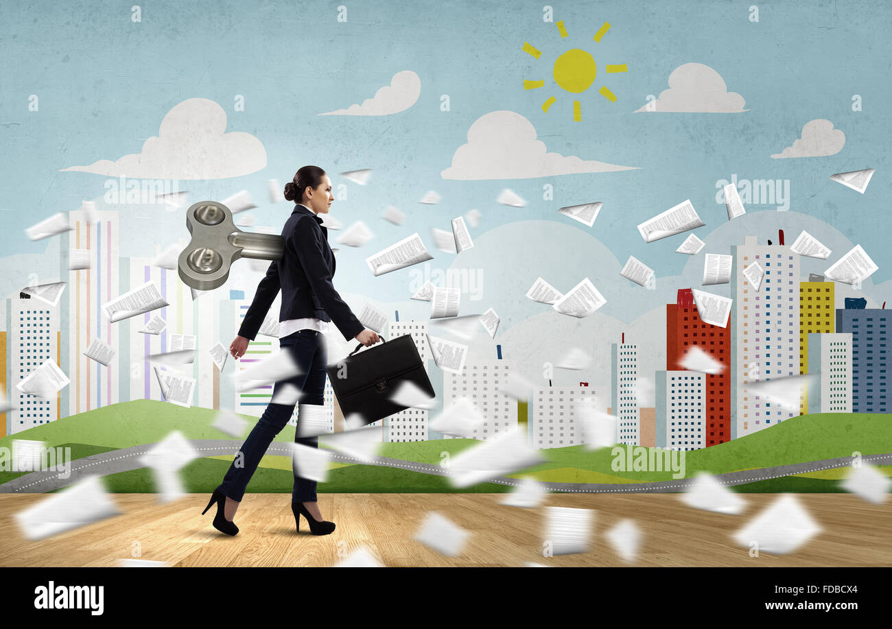 Young businesswoman walking with wind up key in his back Stock Photo ...