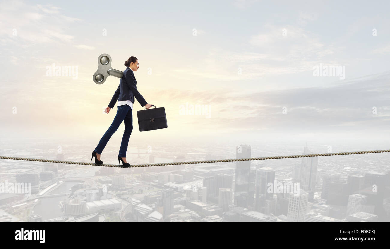 Young businesswoman walking with wind up key in his back Stock Photo ...