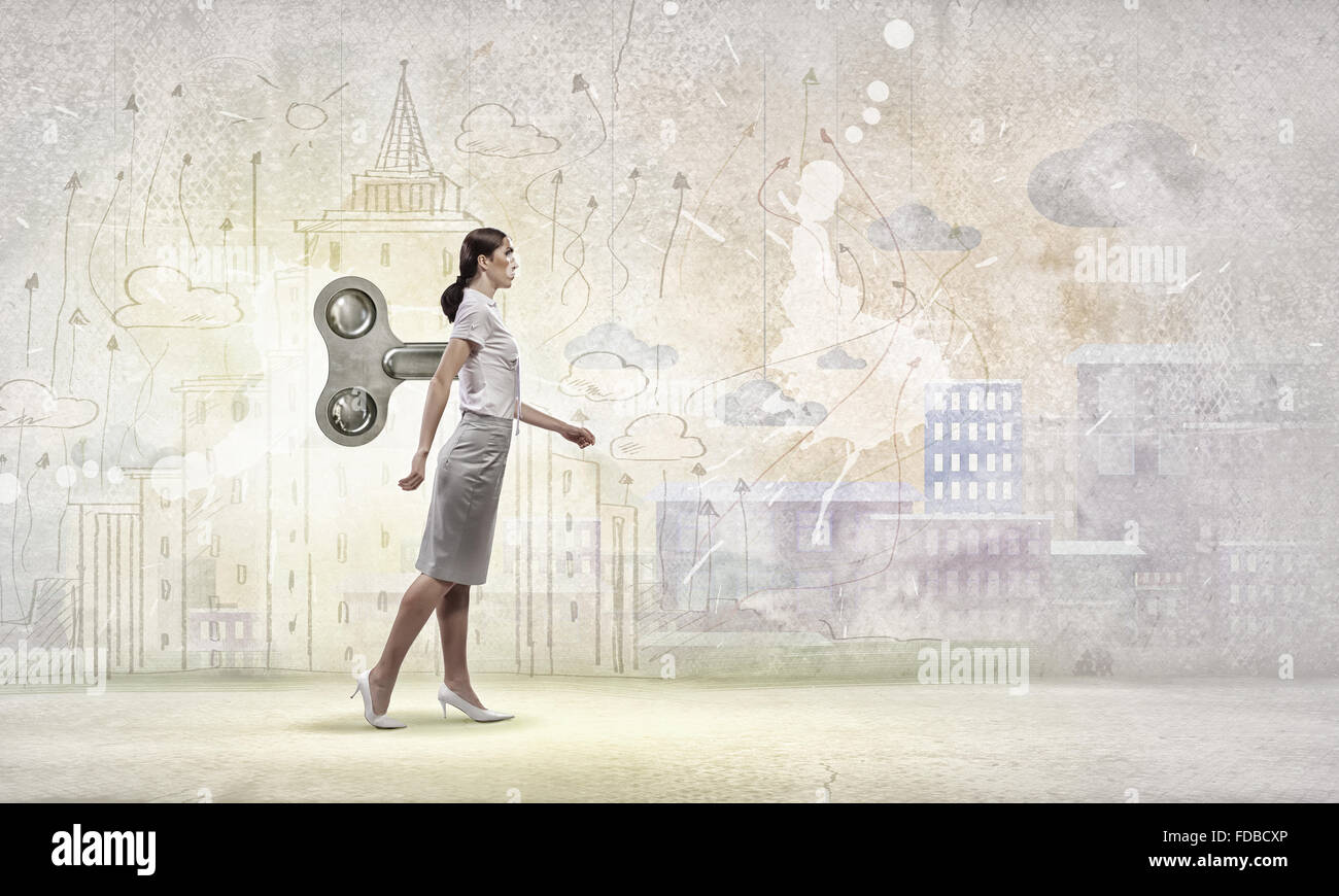 Young businesswoman walking with wind up key in his back Stock Photo ...