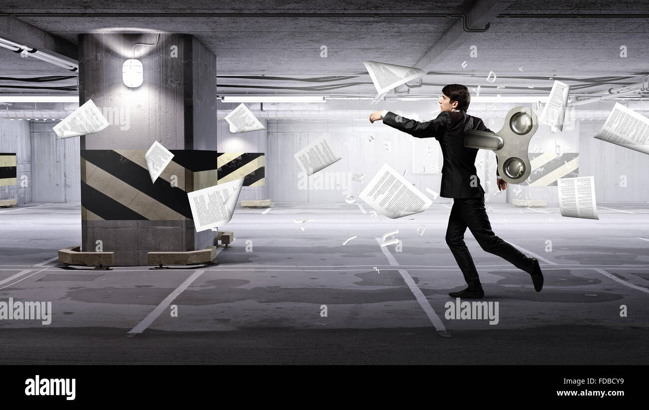 Young businessman walking with wind up key in his back Stock Photo - Alamy