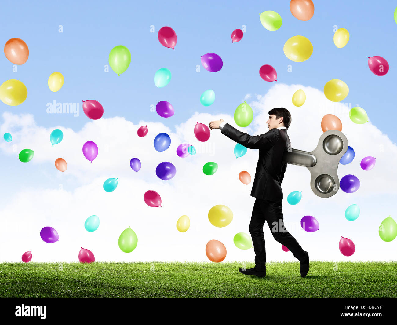 Young businessman walking with wind up key in his back Stock Photo - Alamy