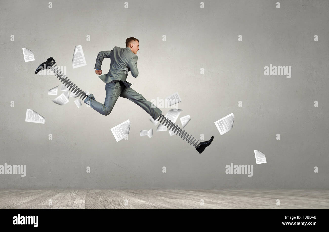 Businessman in suit jumping with big springs on feet Stock Photo - Alamy