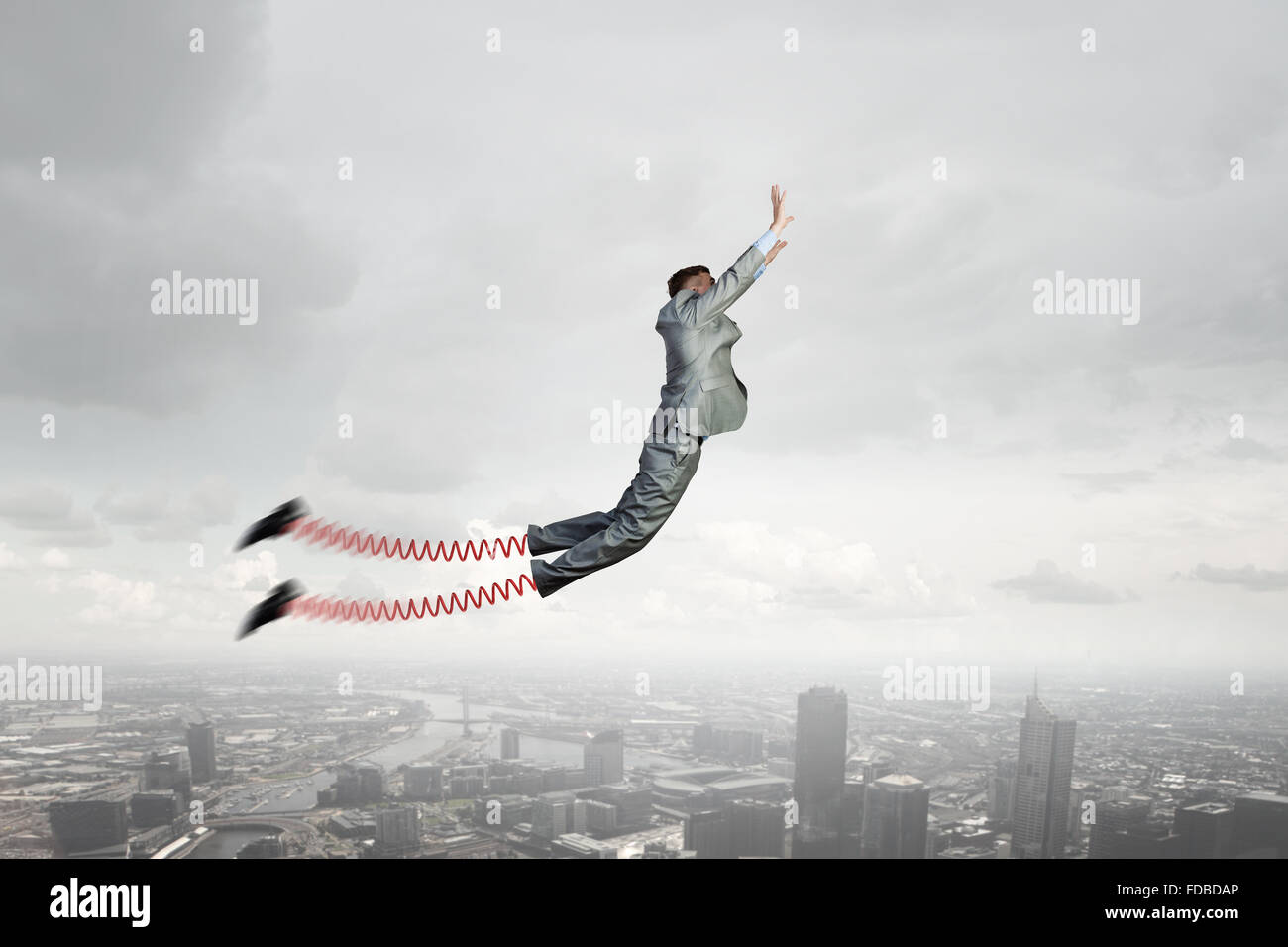Businessman in suit jumping with big springs on feet Stock Photo - Alamy