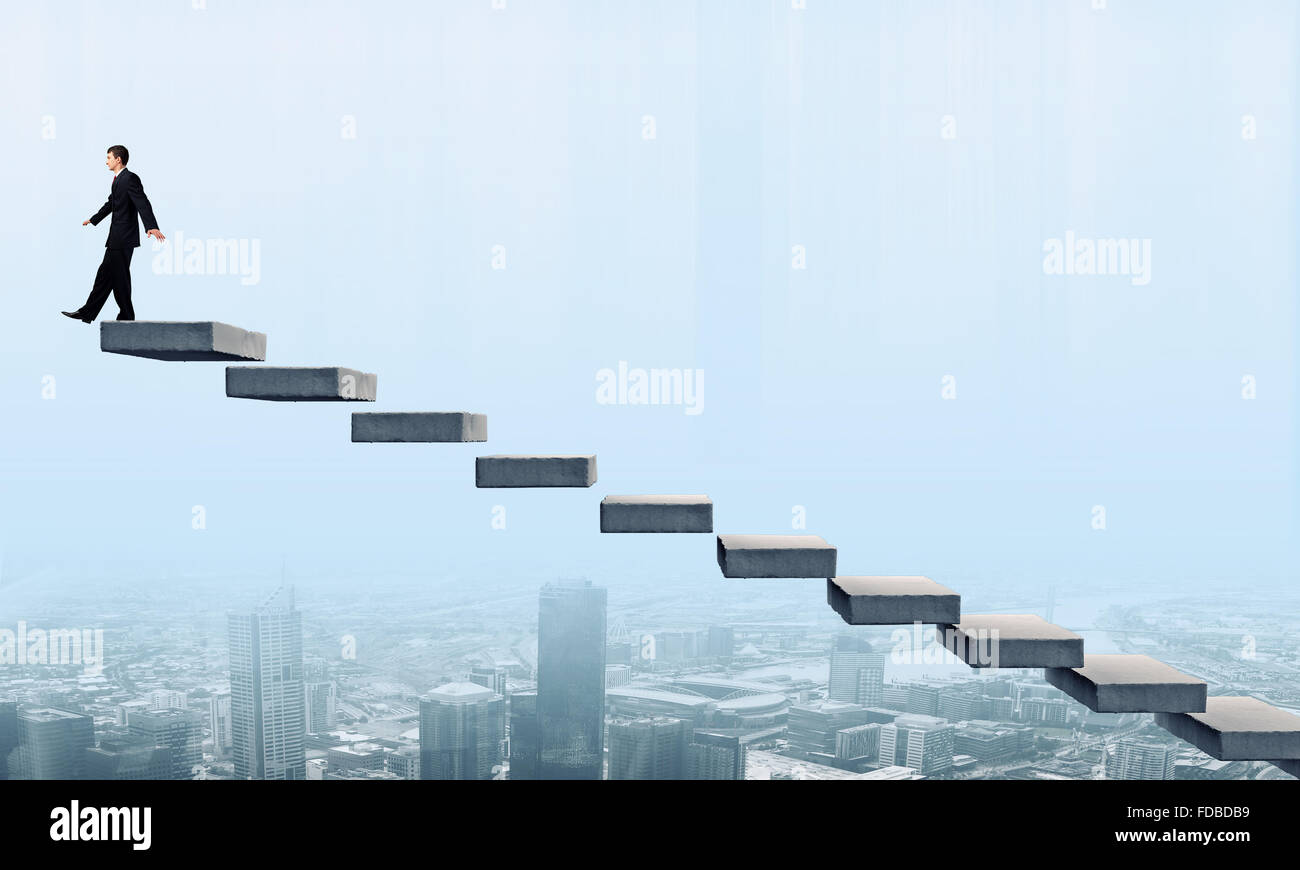 Young businessman walking up on staircase representing success concept ...