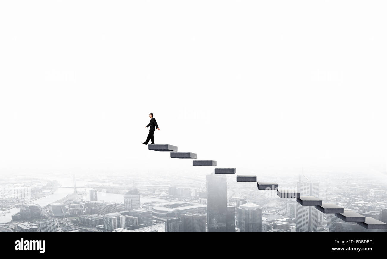 Young businessman walking up on staircase representing success concept ...