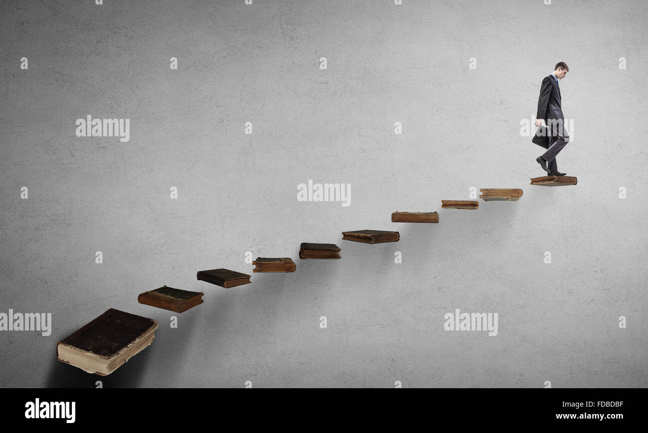 Businessman walking on career ladder made of books Stock Photo - Alamy