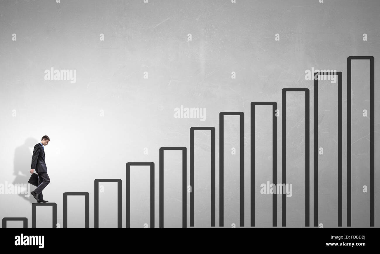 Young businessman walking up on growing graph representing success ...
