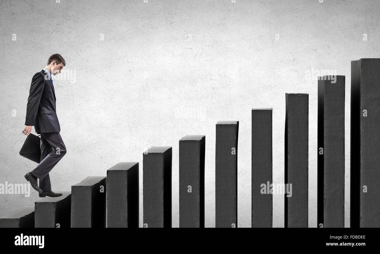 Young businessman walking up on growing graph representing success ...