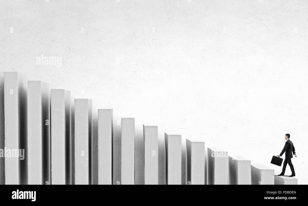 Young businessman walking up on growing graph representing success ...