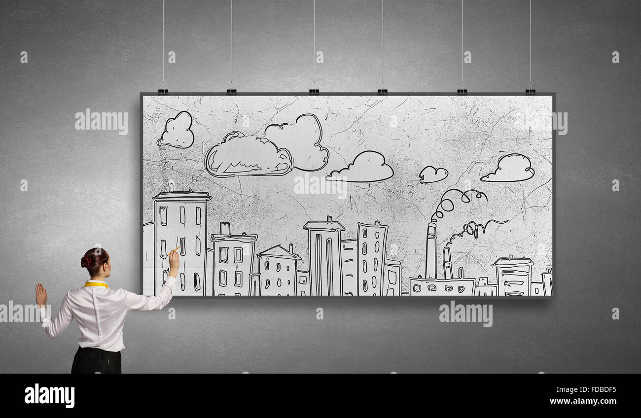 Rear view of businesswoman drawing buildings on white banner Stock ...