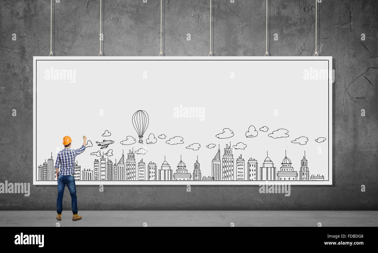 Rear view of builder man drawing construction project on white banner ...