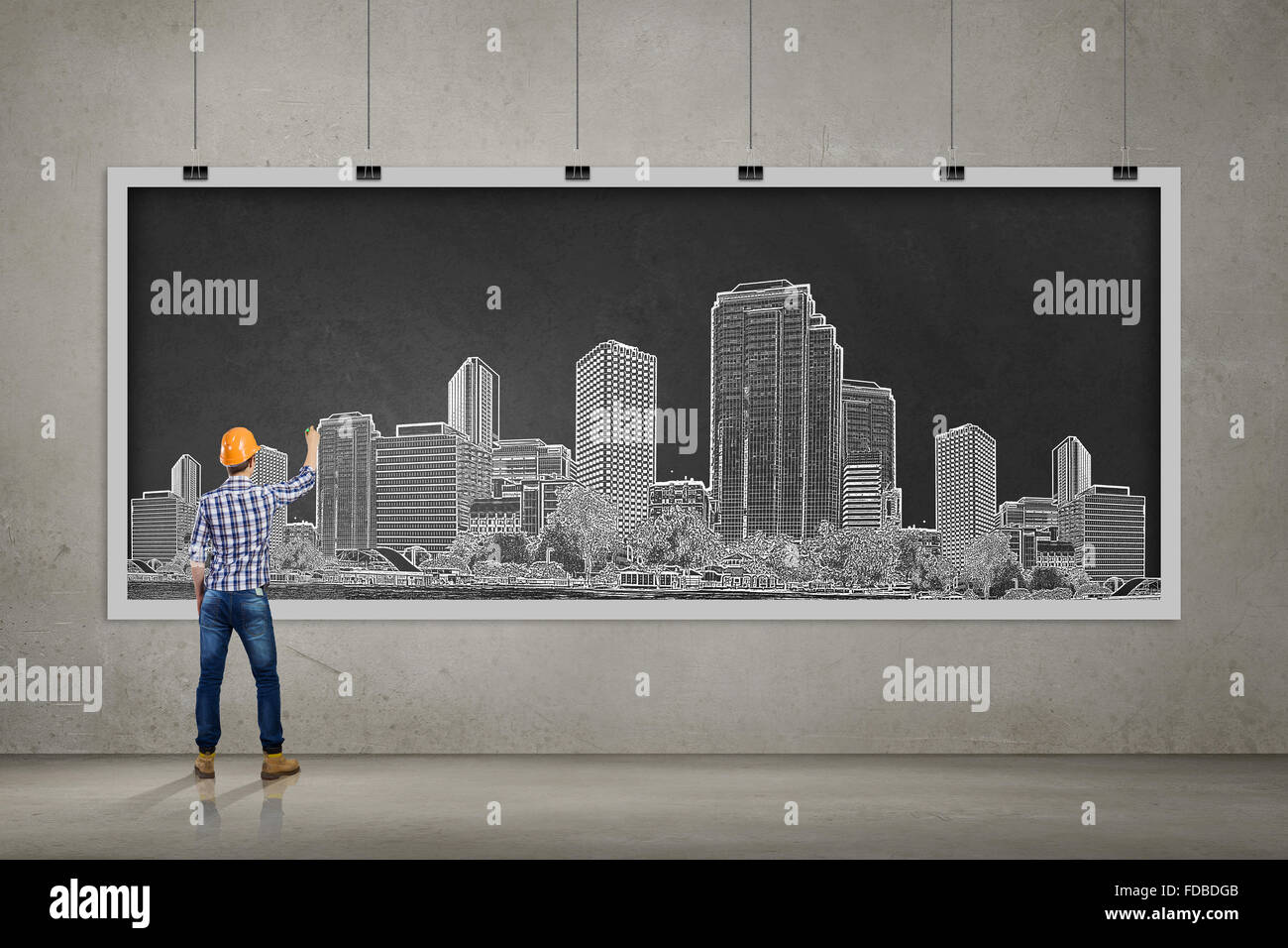 Rear view of man engineer in helmet drawing on chalkboard Stock Photo ...