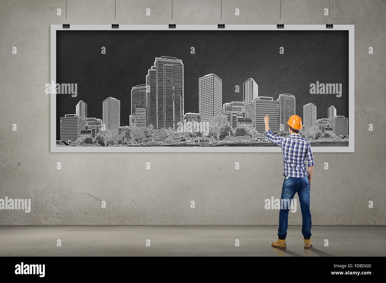 Rear view of man engineer in helmet drawing on chalkboard Stock Photo ...