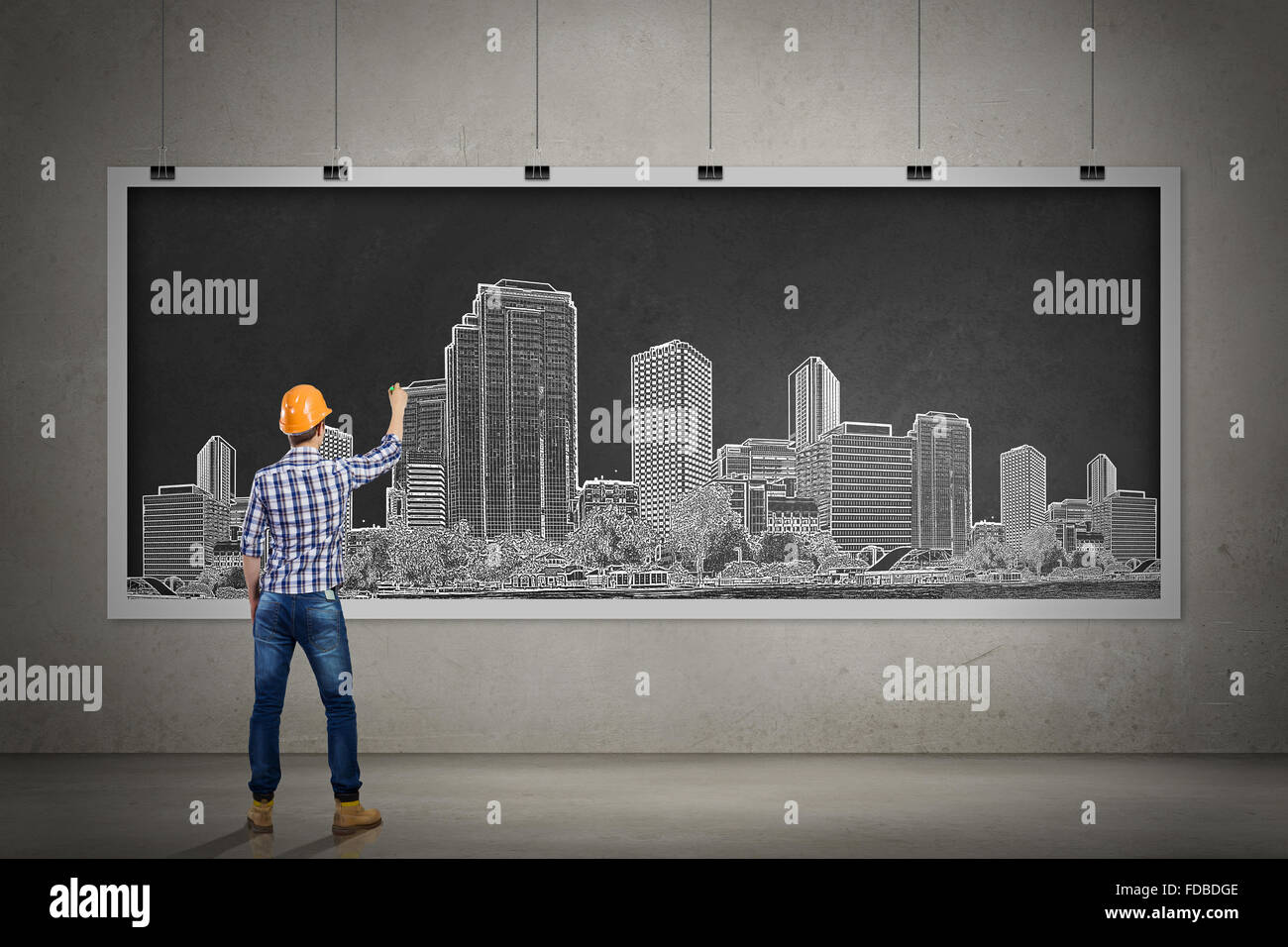 Rear view of man engineer in helmet drawing on chalkboard Stock Photo ...