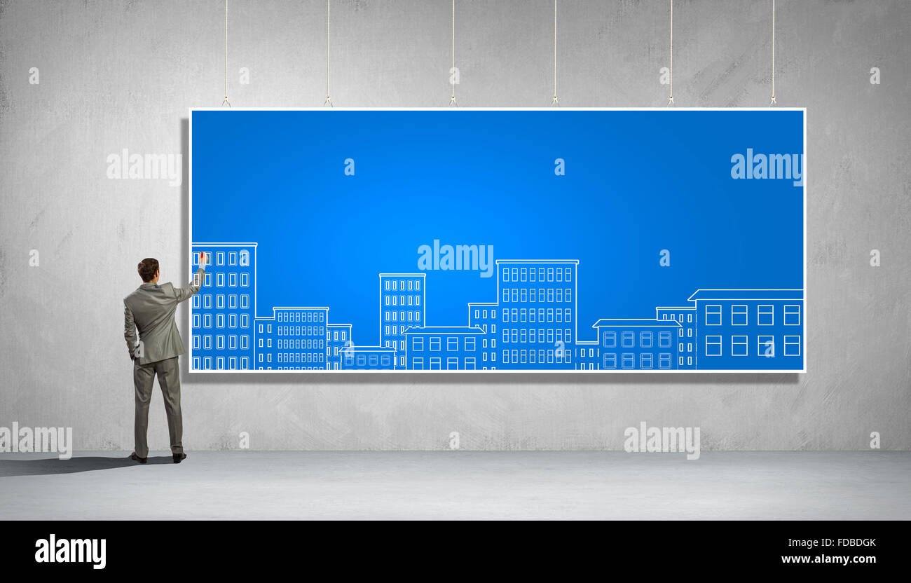 Rear view of builder man drawing construction project on blue banner ...