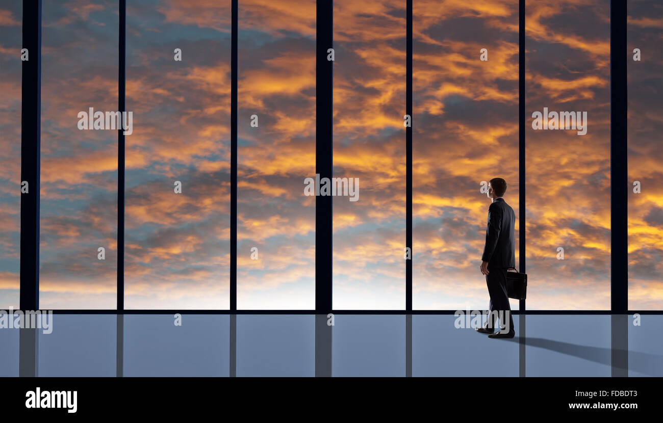 Back view of businessman looking on sunrise in office window Stock ...