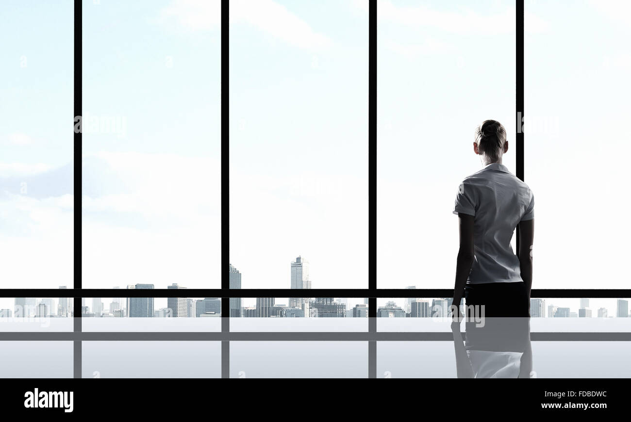 Back view of businesswoman looking in office window Stock Photo - Alamy