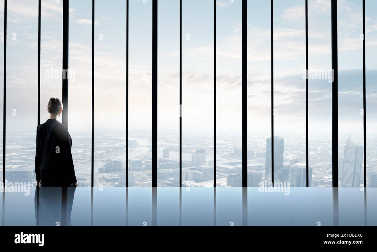 Back view of businesswoman looking in office window Stock Photo - Alamy