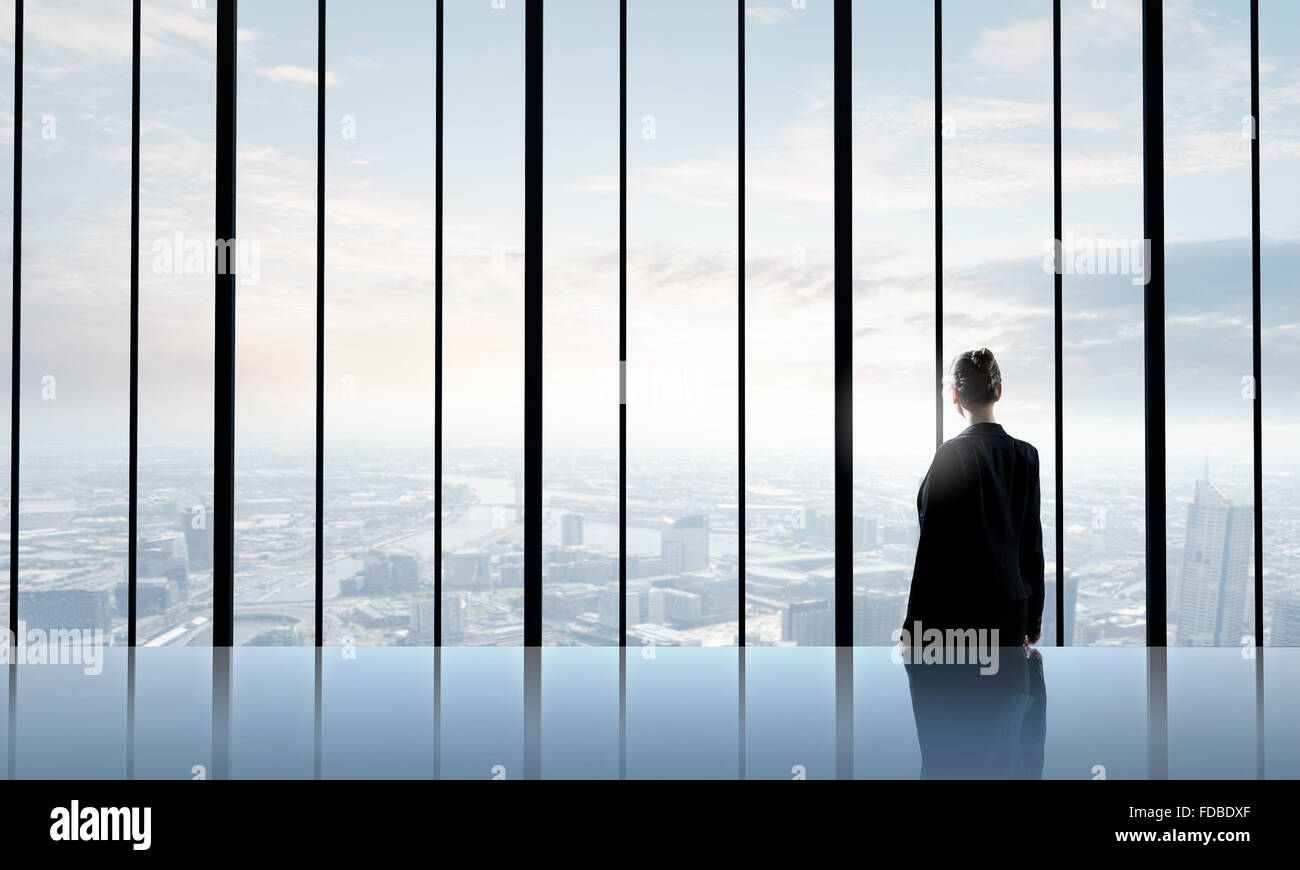 Back view of businesswoman looking in office window Stock Photo - Alamy