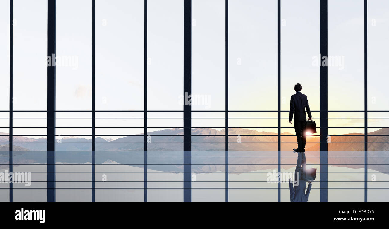 Back view of businessman looking on sunrise in office window Stock ...