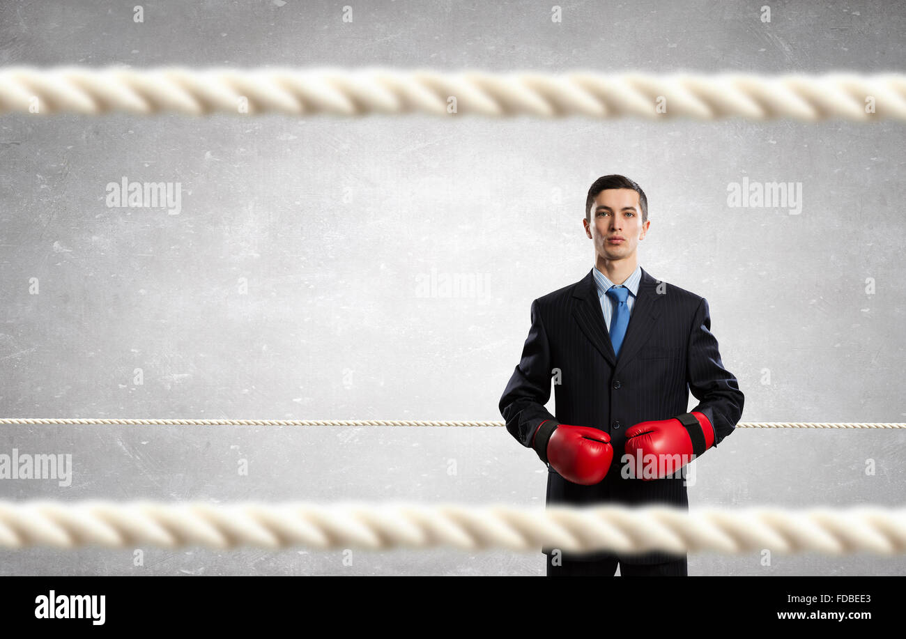 Young businessman in red boxing gloves on cement background Stock Photo ...