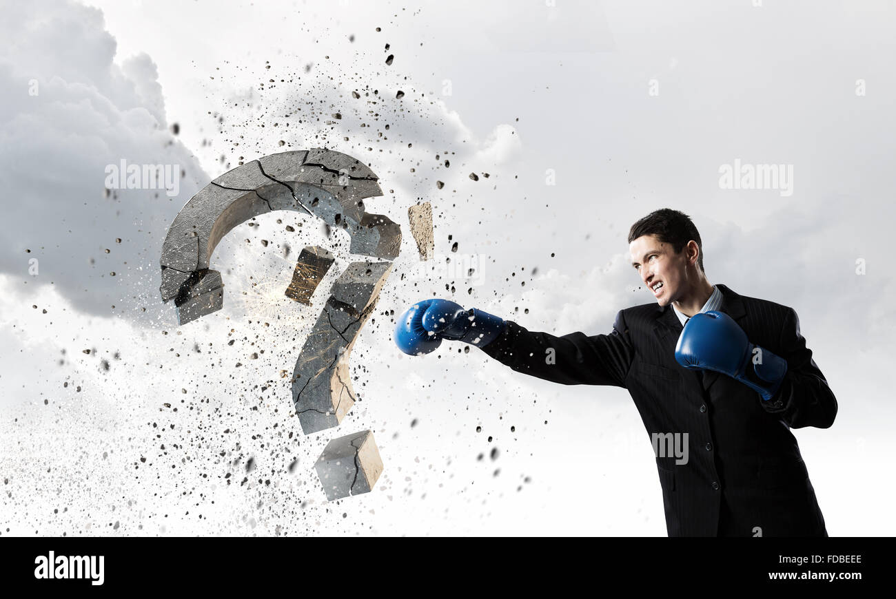 Young businessman in blue boxing gloves breaking question mark Stock ...