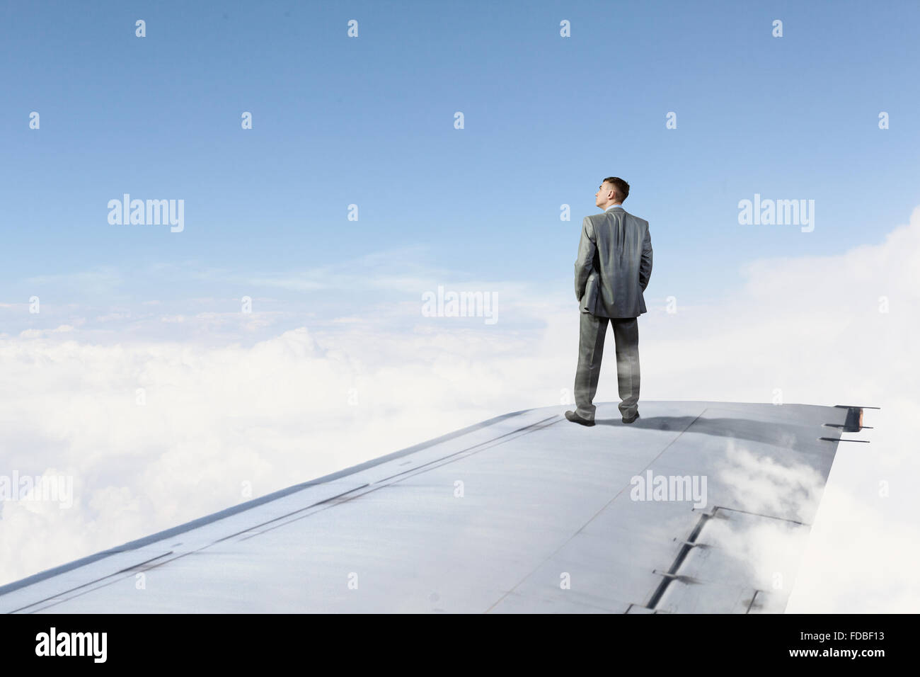 Young businessman standing on edge of airplane wing Stock Photo - Alamy