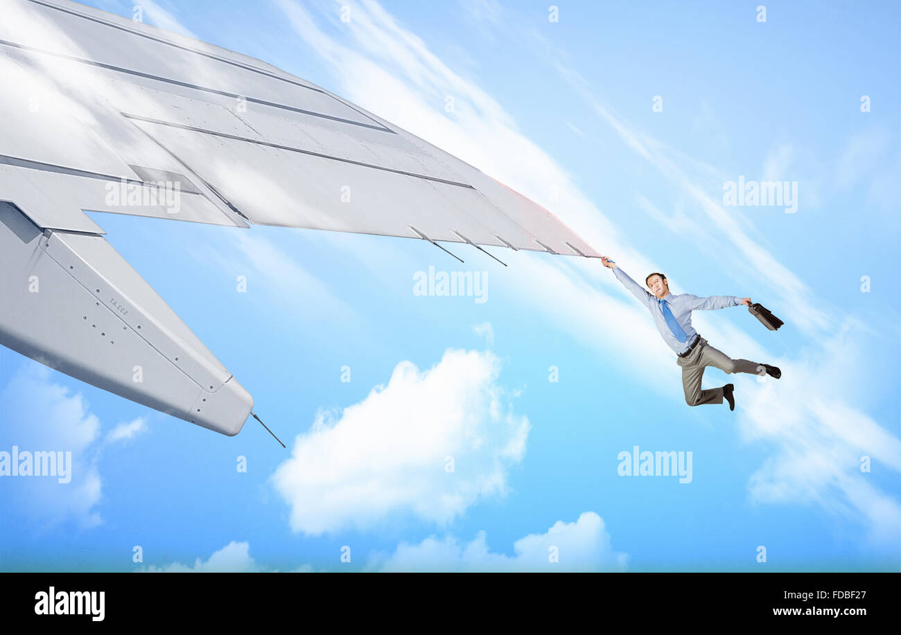 Young businessman flying on edge of airplane wing Stock Photo - Alamy