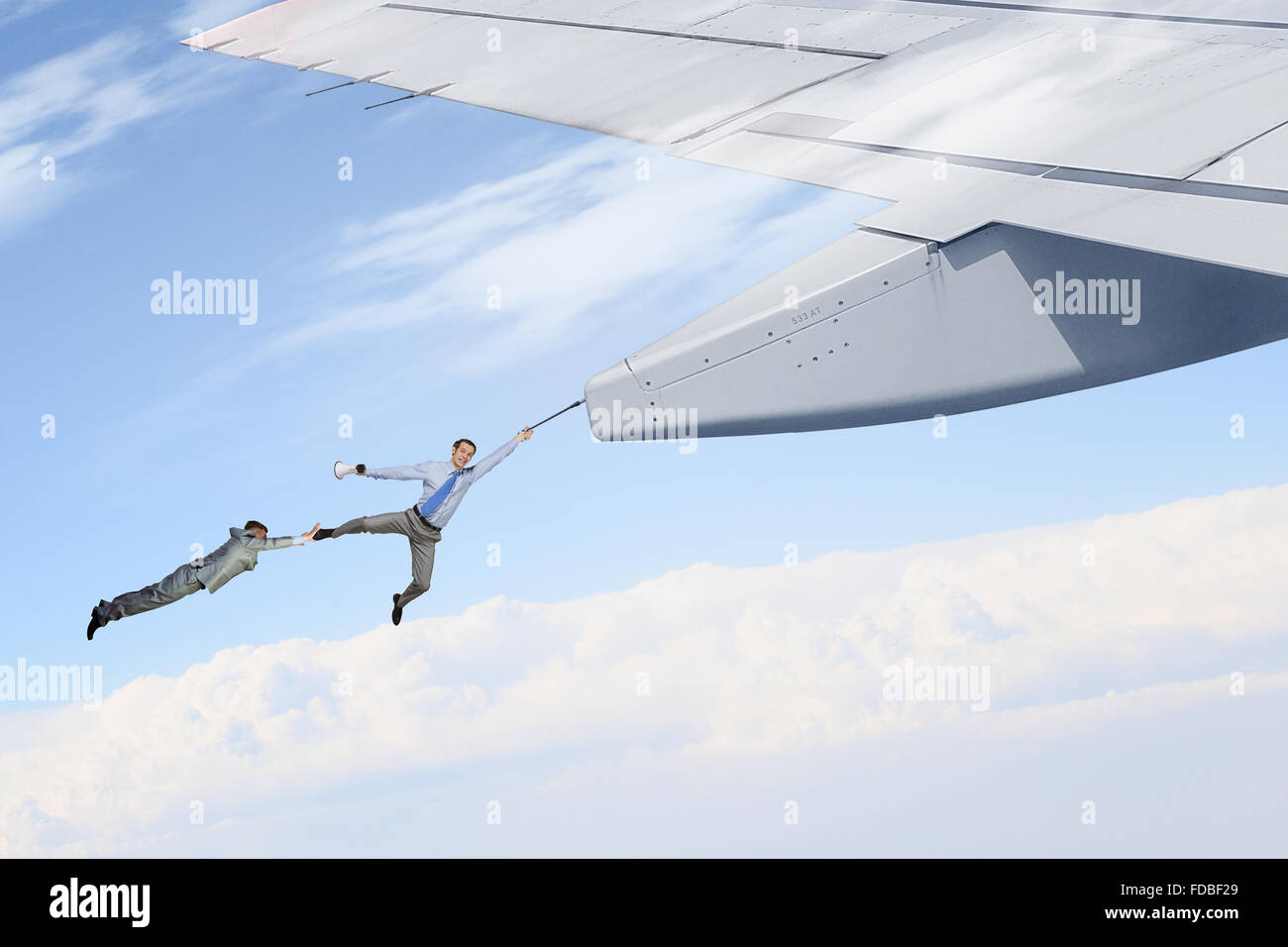 Young businessmen flying on edge of airplane wing Stock Photo - Alamy