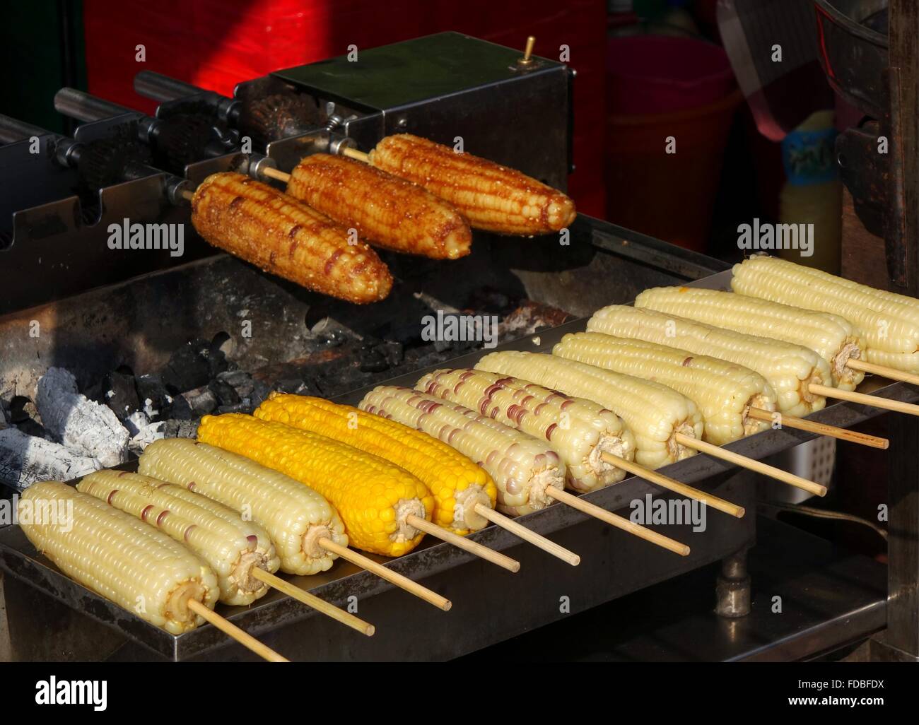 Grilled corn cobs with barbecue sauce are a popular street food in ...