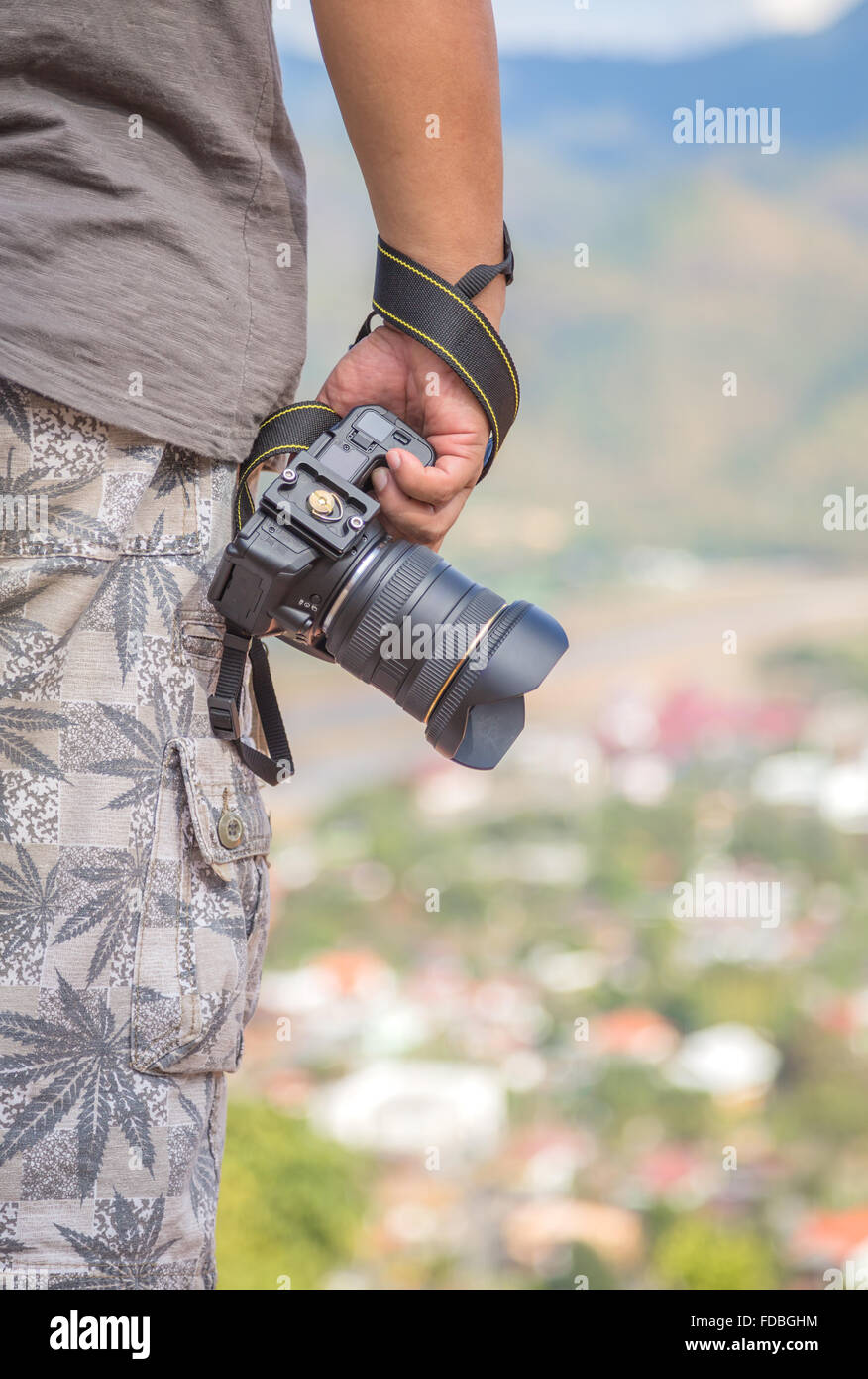 Photographer holding camera outdoors Stock Photo - Alamy