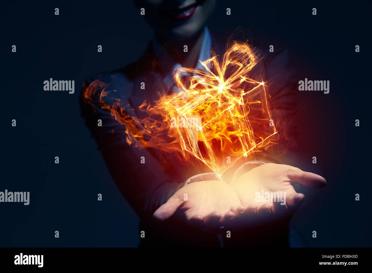 Glowing fire gift box icon on dark background Stock Photo - Alamy