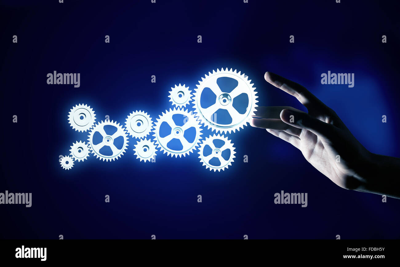 Business person hand touching gear mechanism representing interaction ...